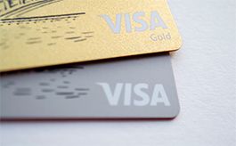 Two Visa cards, one golden and the other one gray.