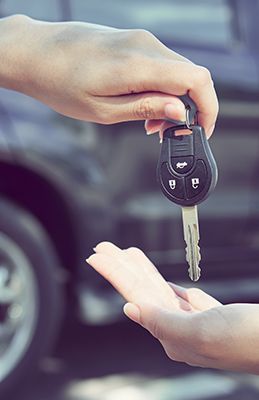 One person giving another a car key.